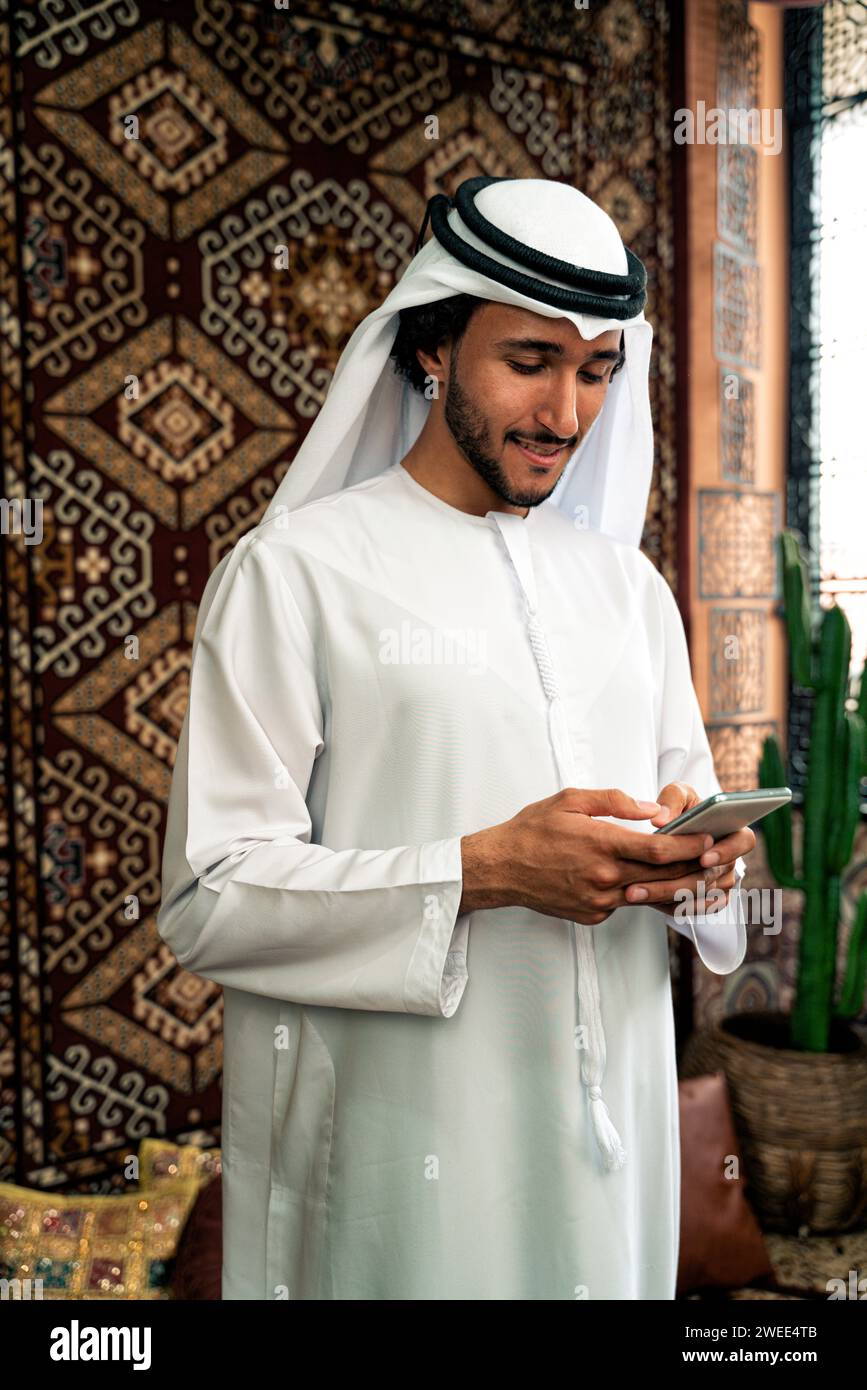 Man from emirati wearing kandura outfit spending time in an arabian ...