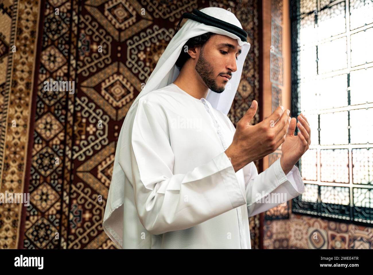 Man from emirati wearing kandura outfit spending time in an arabian ...