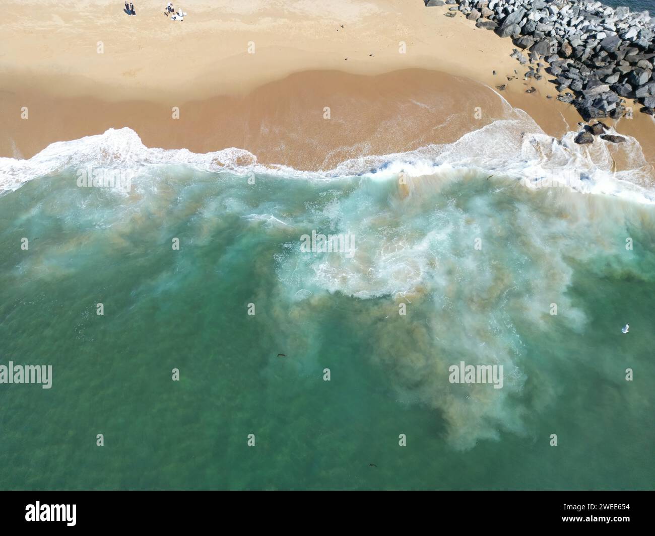 Green water waves hitting sandy beaches Stock Photo - Alamy