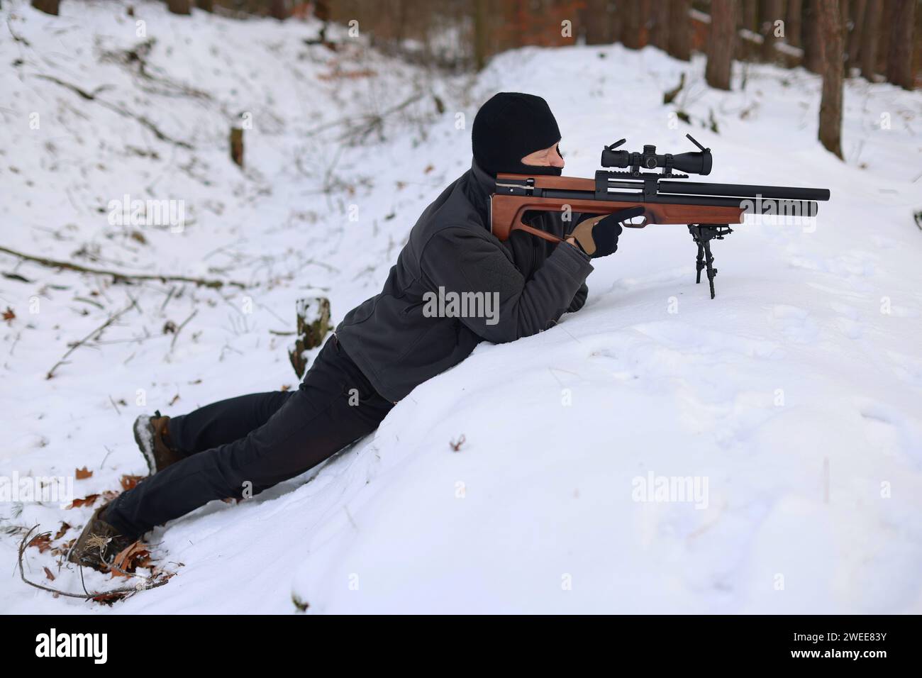 a man with a rifle on the snow and aims at a target Stock Photo - Alamy