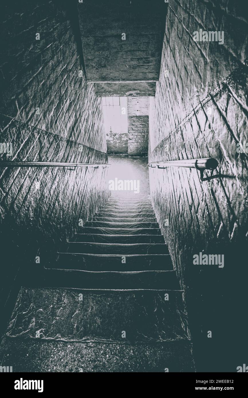 Wooden stair rails going down a narrow painted staircase with worn ...