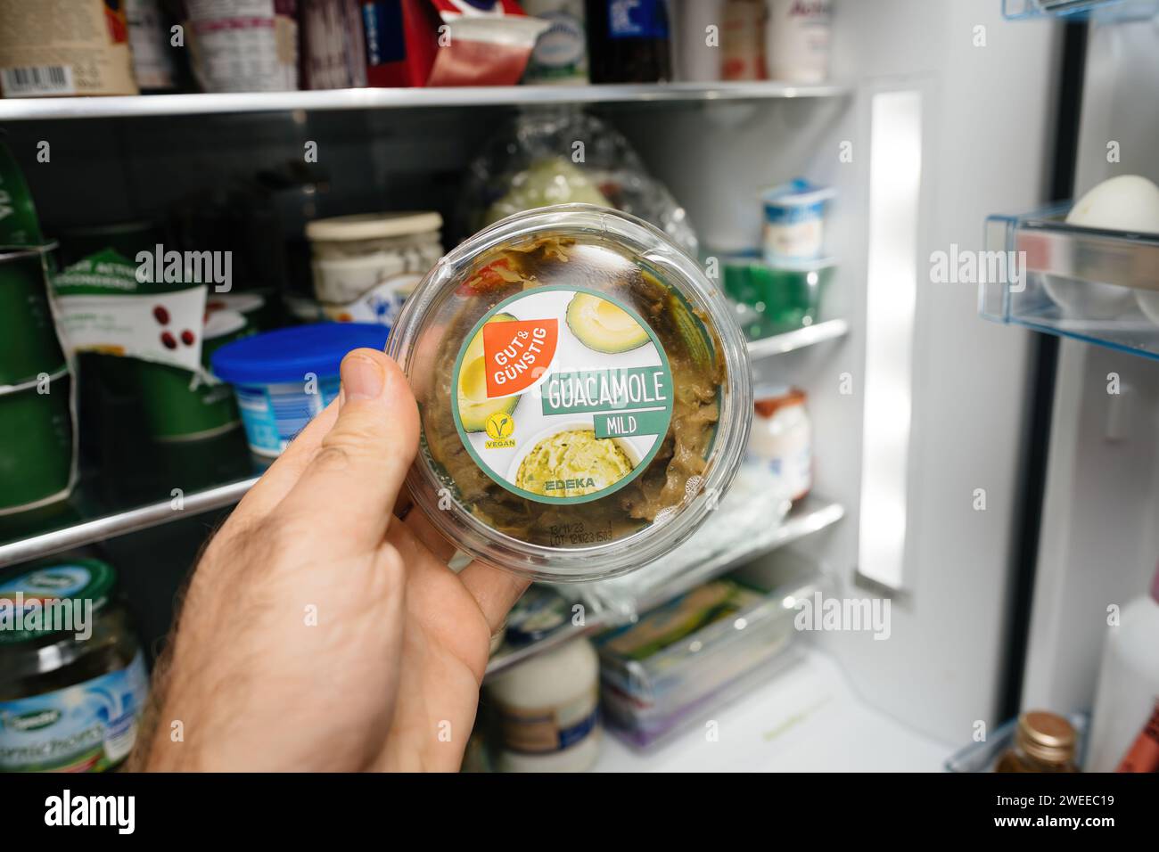 Paris, France - Dec 28, 2023: A male hand retrieves a perished package ...