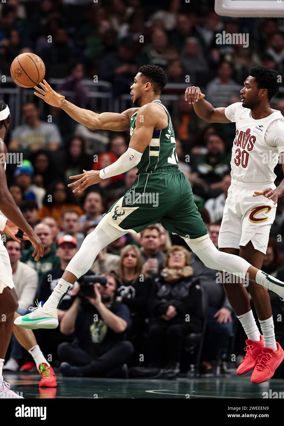 Milwaukee, USA. 24th Jan, 2024. Milwaukee Bucks forward Giannis Antetokounmpo (L) passes the ...