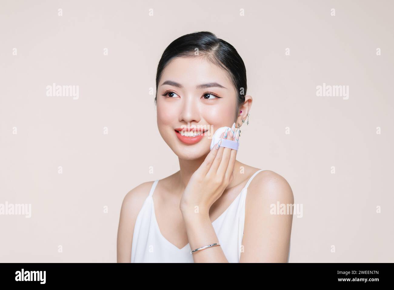 asian woman smile looking happy applying makeup with puff makeup to her ...