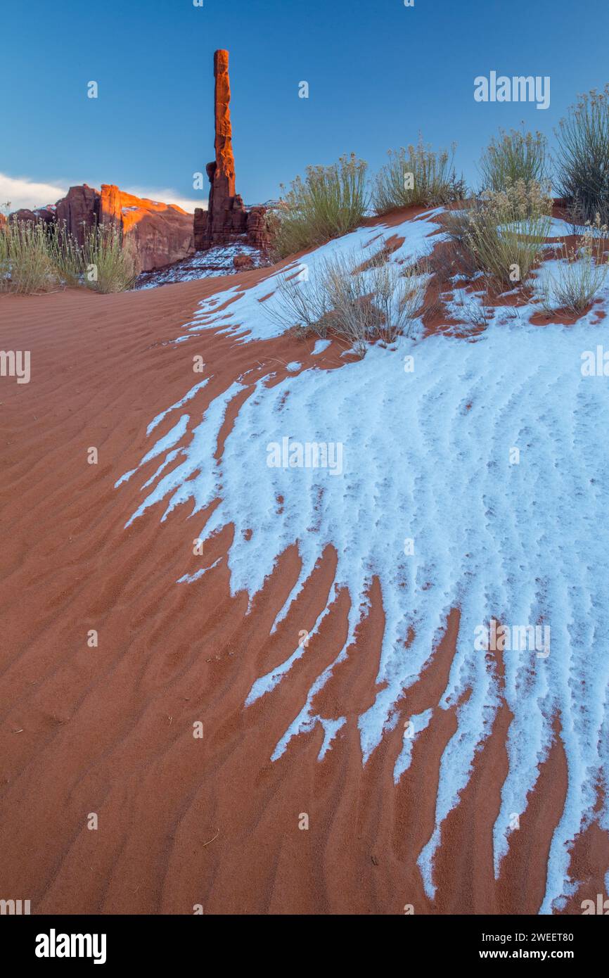 The Totem Pole with snow and rippled sand in the Monument Valley Navajo ...