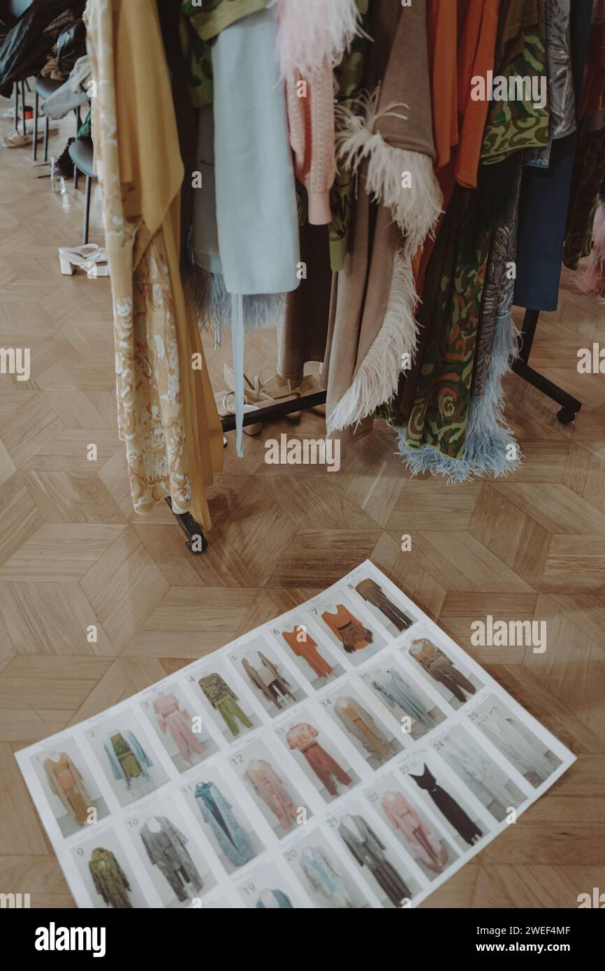 Fashion outfits hanging in a row and photographs of fashion collections ...