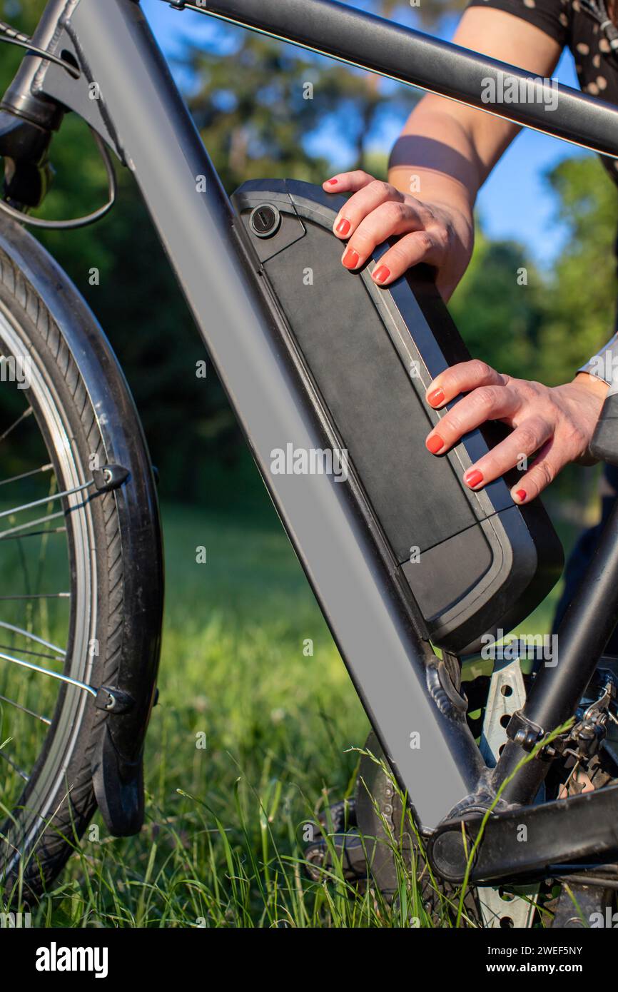 detail of woman holding an electric bike battery mounted on frame Stock ...