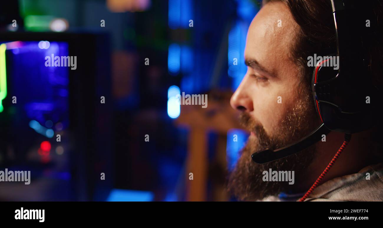 Pro gamer at home talking with teammates using headphones mic ...