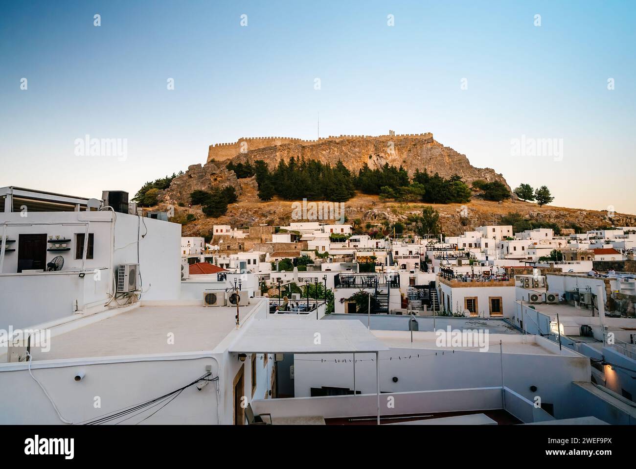 Evening view of the ancient Acropolis of Lindos and snow white houses ...