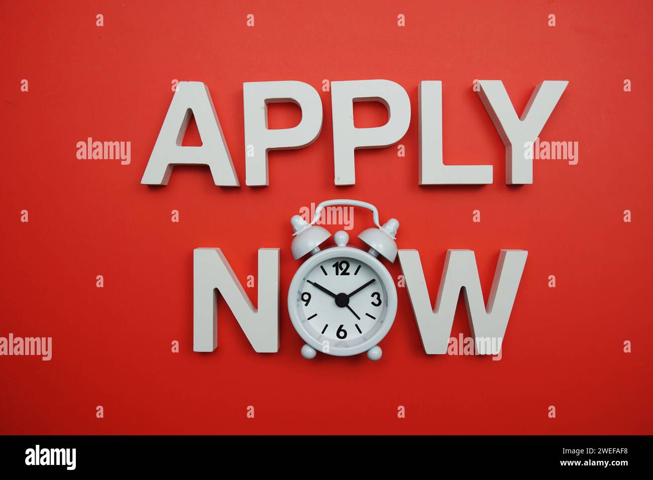 Apply Now alphabet letters on red background Stock Photo - Alamy