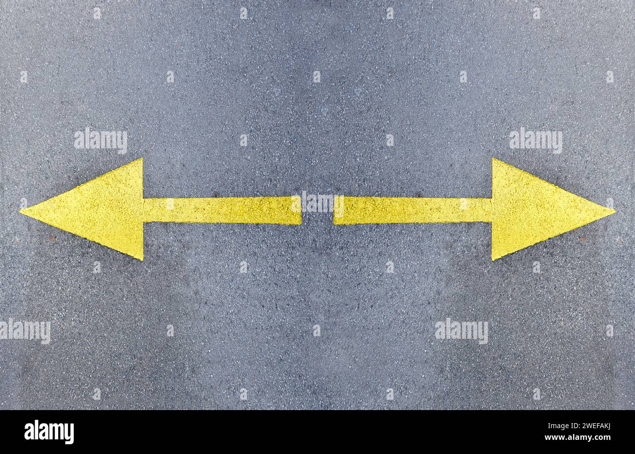 Arrow signs on asphalt road showing direction of movement, close up ...