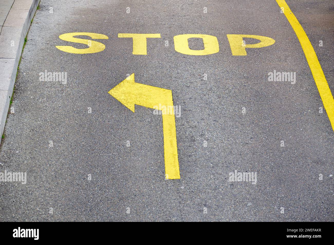 Stop sign on asphalt road showing direction of movement with left arrow ...