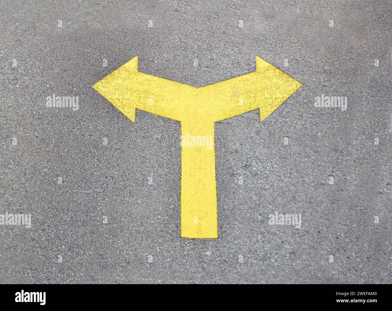 Arrow signs on asphalt road showing direction of movement, close up ...