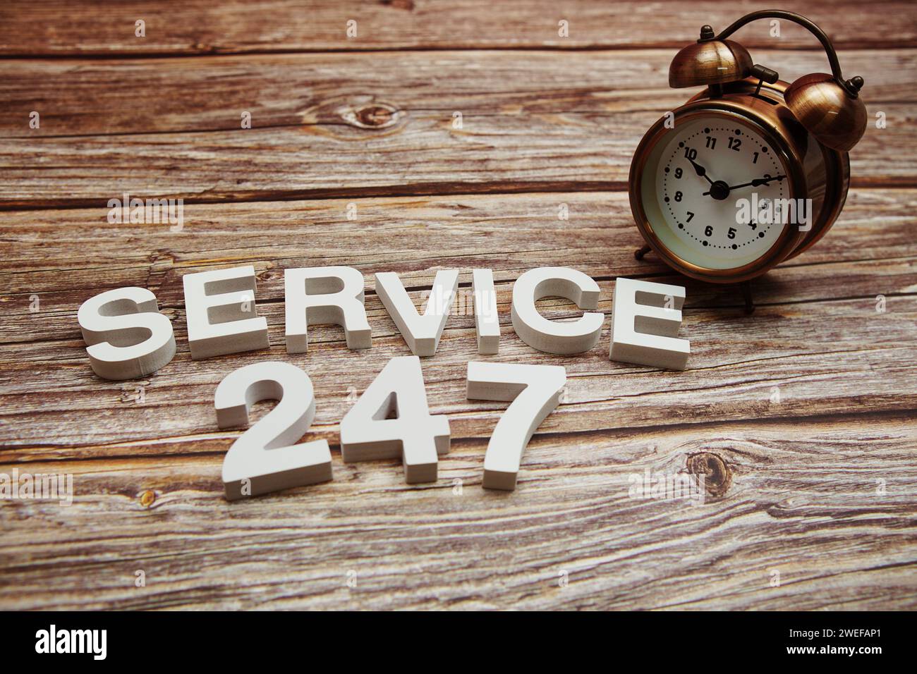 24/7 Service alphabet letters and alarm clock on wooden background ...