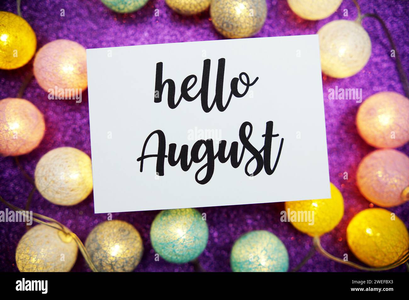 Hello August text on paper card top view on purple bokeh background ...
