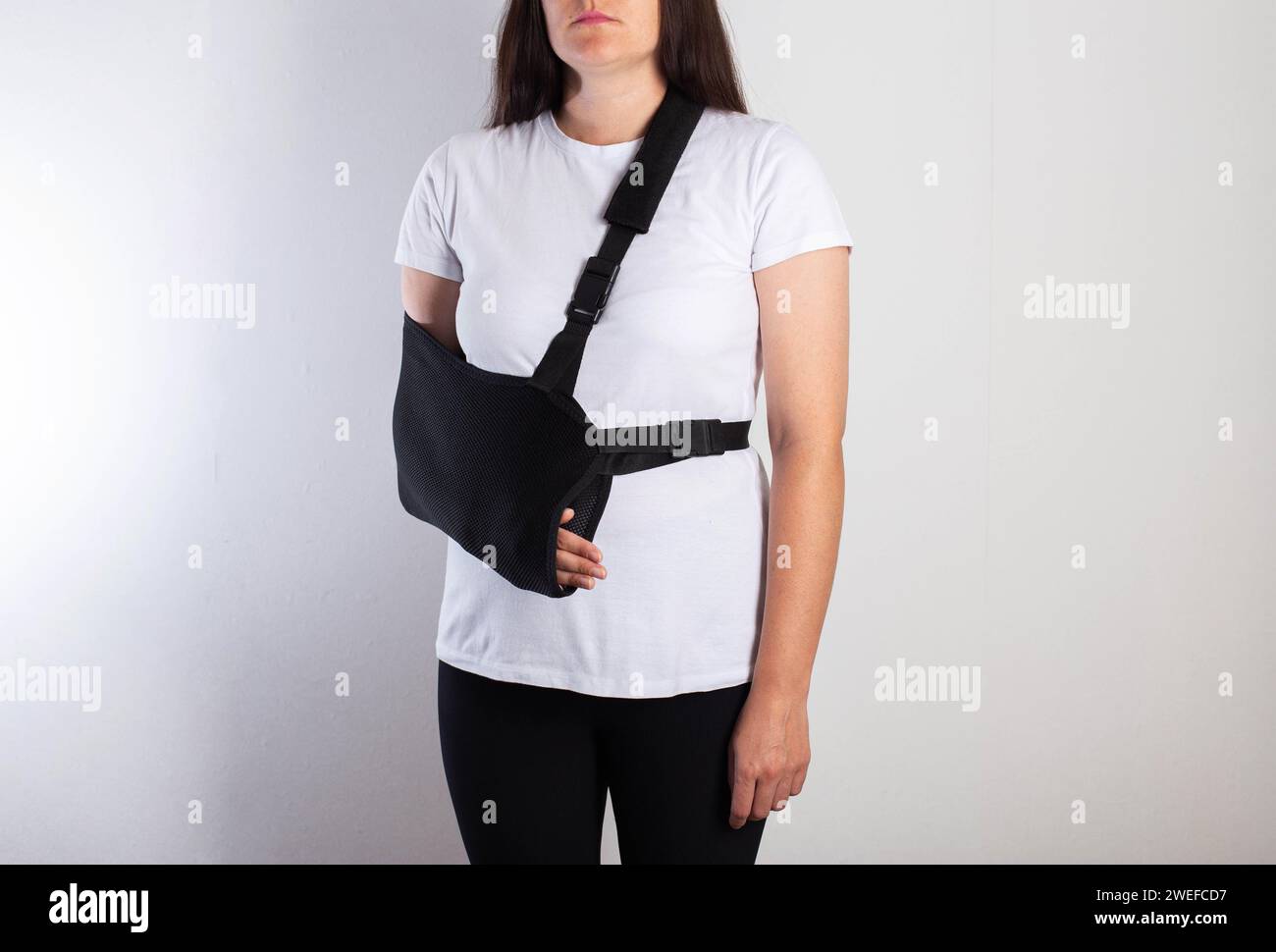 A girl in white with a black support bandage for her arm after a ...
