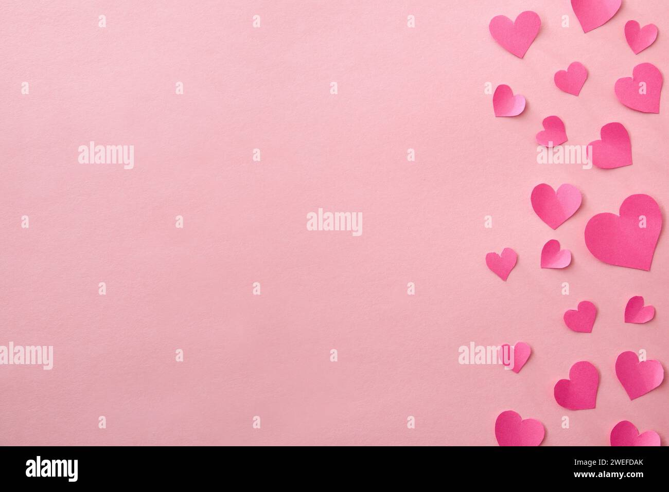 Love background with fuxia pink heart cutouts of various sizes on the ...