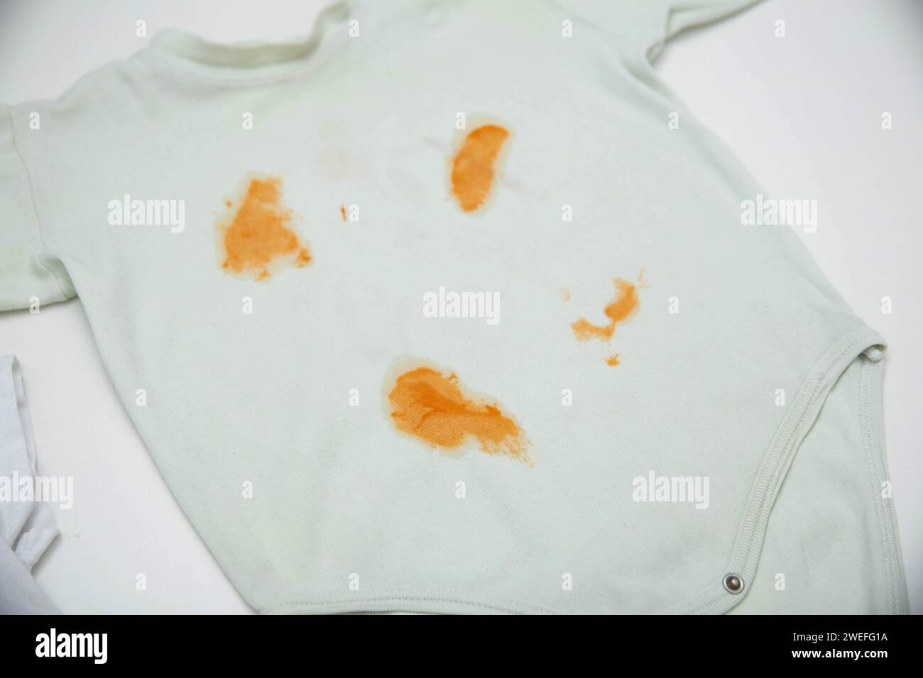 Orange stains on children's clothes from fruit puree. The concept of ...
