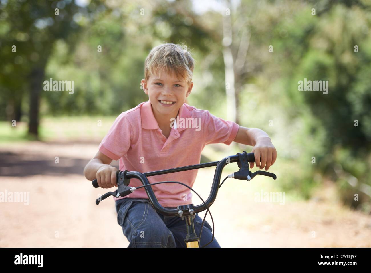 Nature, smile and portrait of child on bicycle riding in outdoor field ...