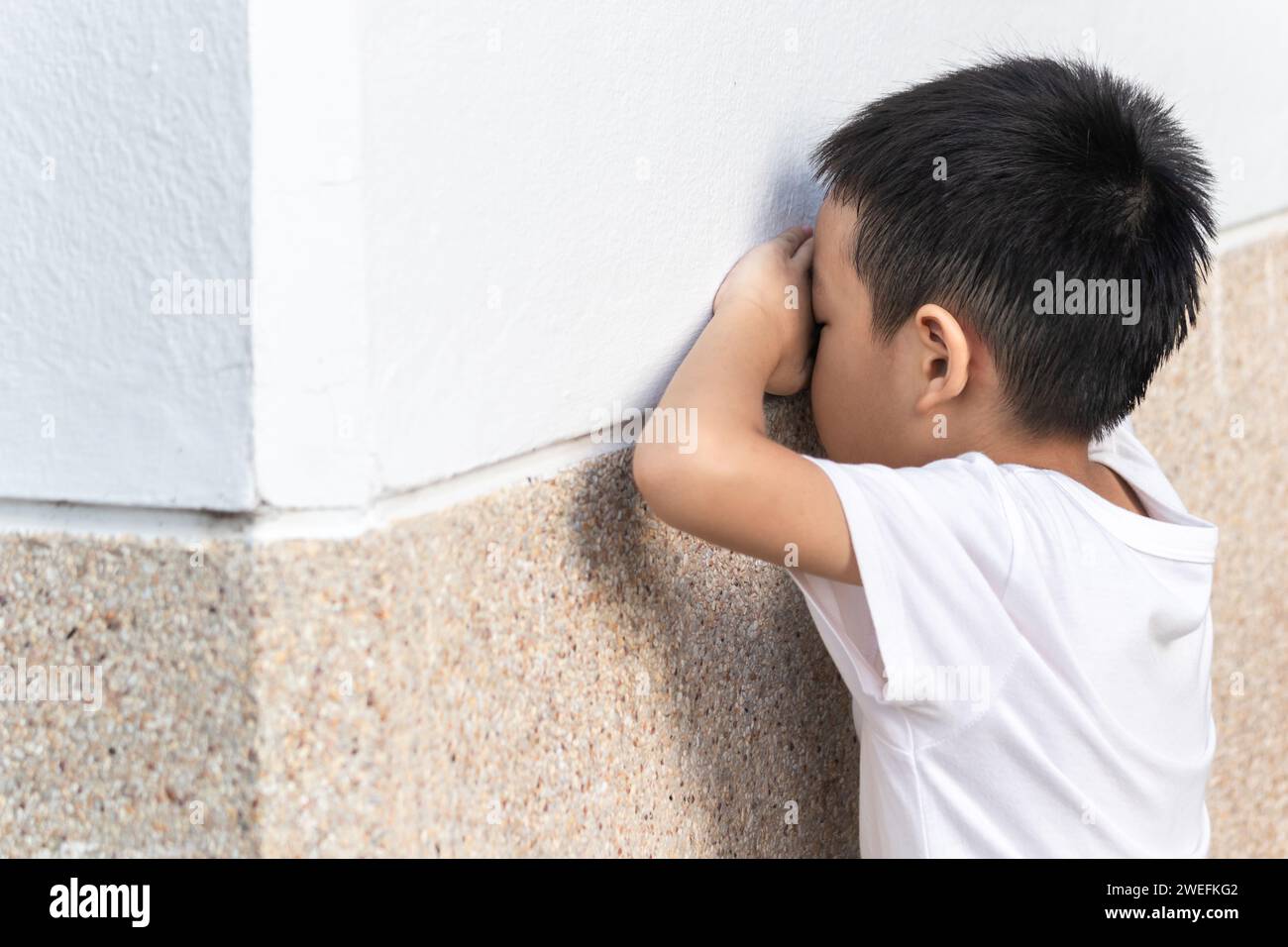 The cute Asian little boy is playing hide and seek with the funny ...