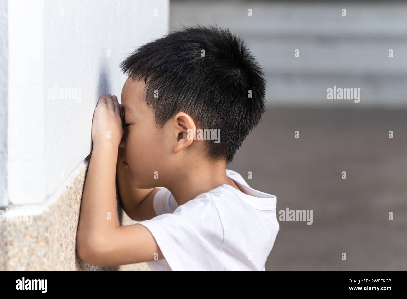 The cute Asian little boy is playing hide and seek with the funny ...