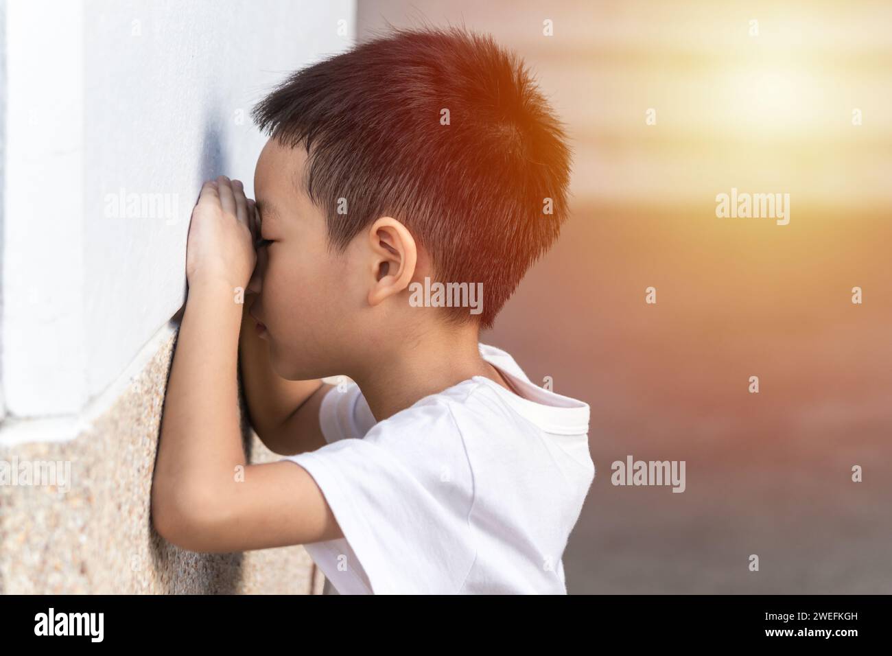 The cute Asian little boy is playing hide and seek with the funny ...