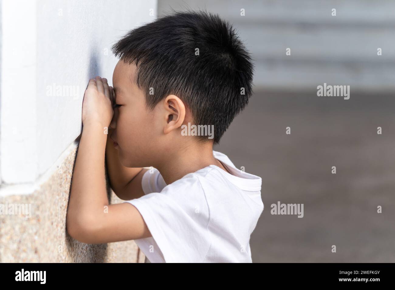The cute Asian little boy is playing hide and seek with the funny ...
