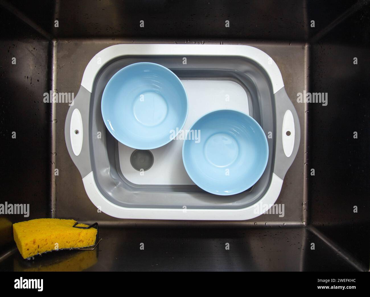 Two blue clean plates in the sink basin. The concept of washing and ...