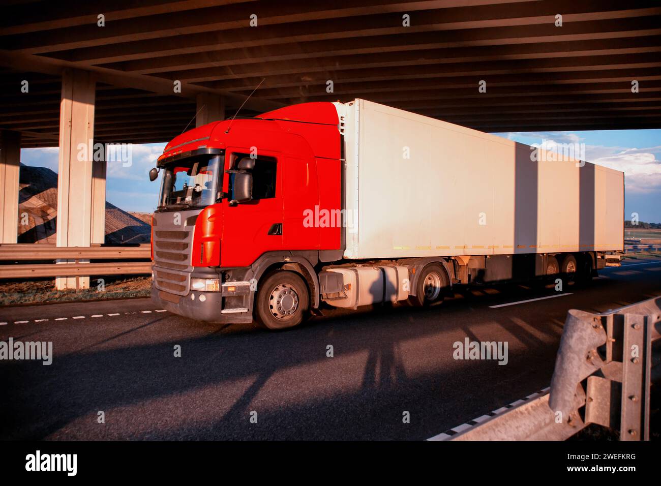 A red tractor with an isothermal refrigerated semi-trailer transports ...