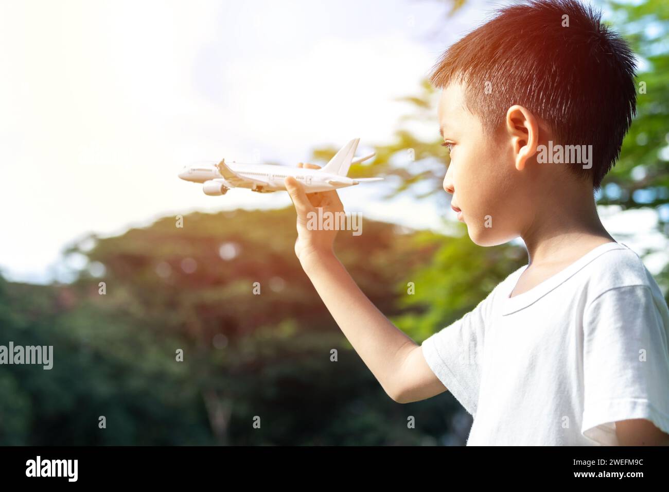 Cute Asian child playing airplane in the park outdoors Happy Asian boy ...