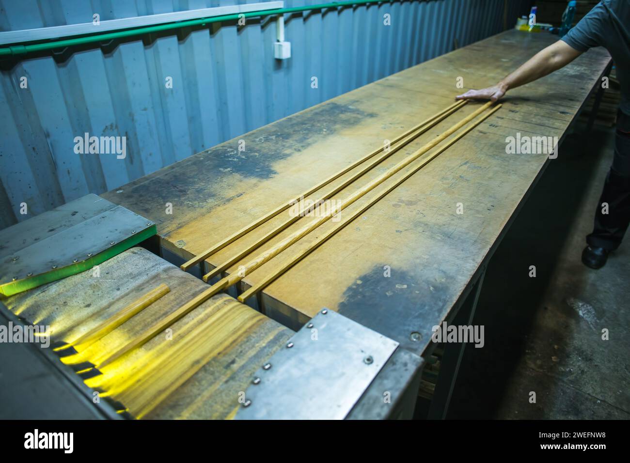 hardwood sticks entering lacquering machine Stock Photo - Alamy