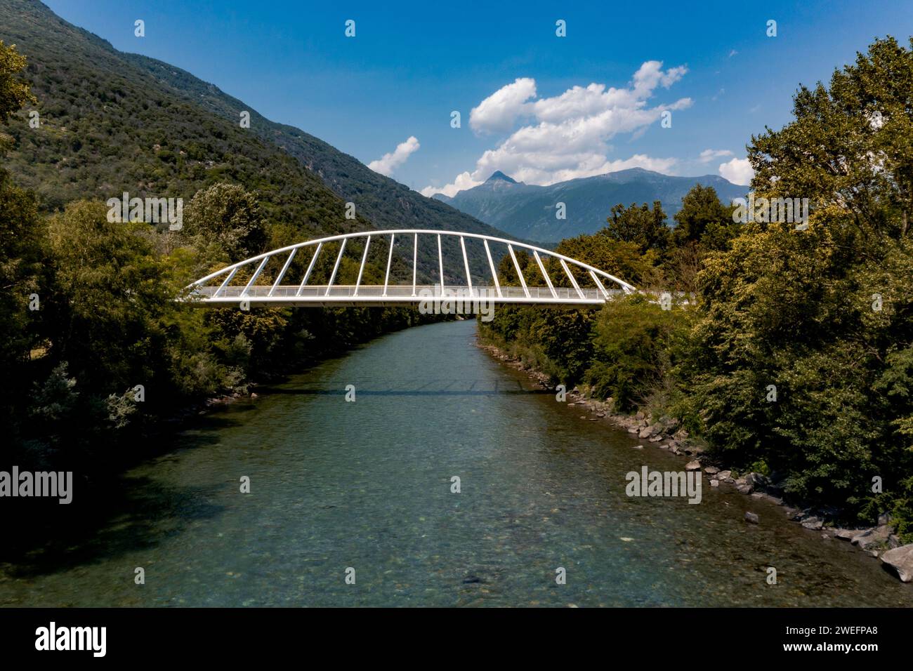 Pedestrian bridge over a small Swiss river, the Ticino. In summer, the ...