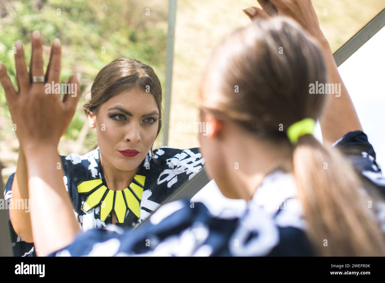 introspective young woman looking at a mirror Stock Photo - Alamy