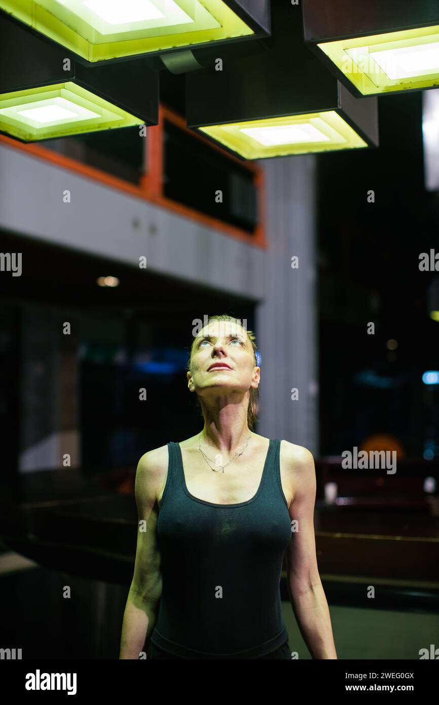 woman looking at bright light above her Stock Photo - Alamy