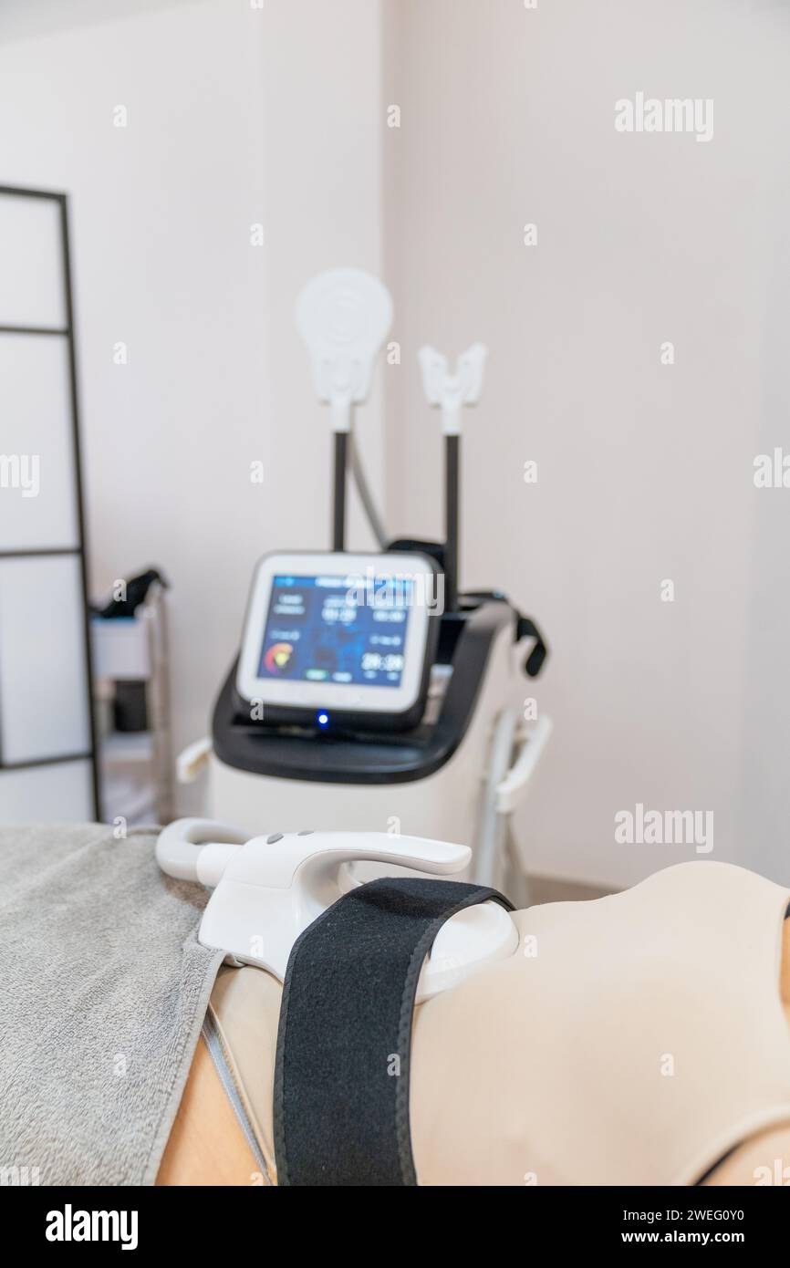 A vertical shot of a person undergoing abdominal electrostimulation ...