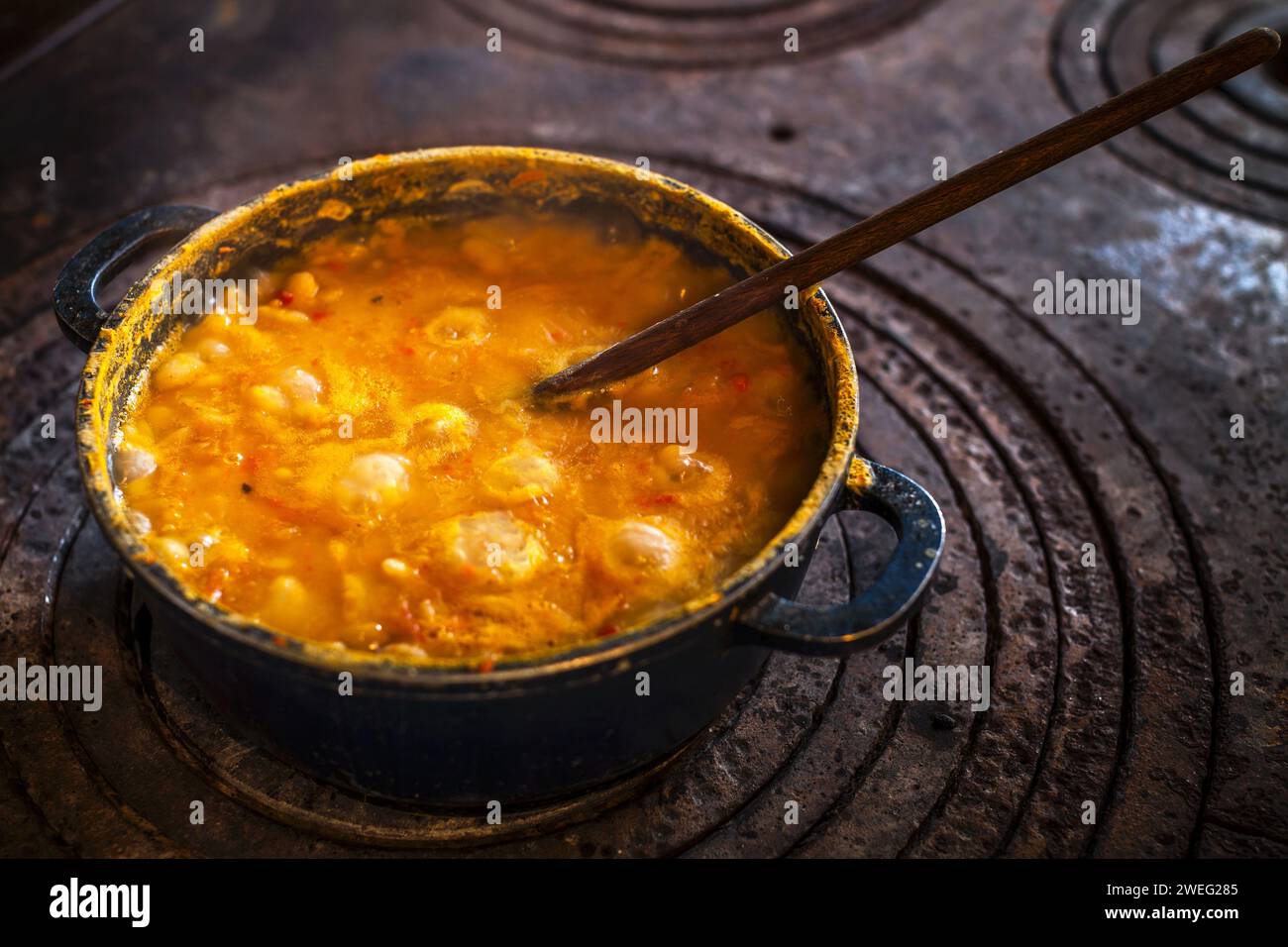 Beans with chilly cowboy meal coocing on fire in a dirty, rusty iron ...