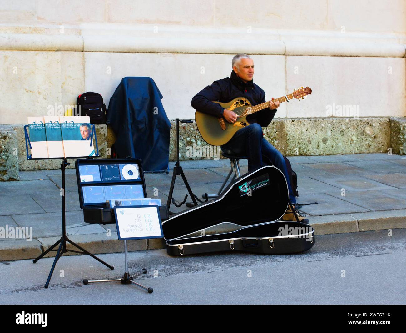 A street musician plays the guitar in the streets of Salzburg, Austria ...