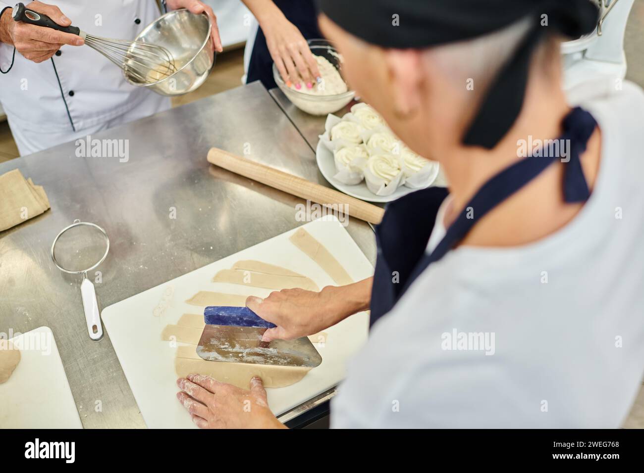 cropped view of mature chef using cutting board on kitchen next to her ...