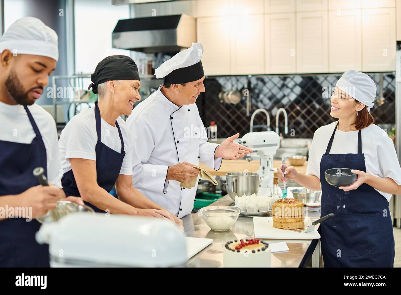joyous multiracial chefs in blue aprons and toques having fun while ...