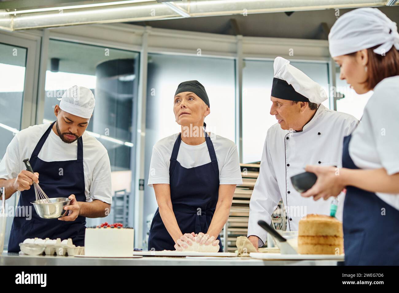 good looking mature chief cook talking to his hard working interracial ...