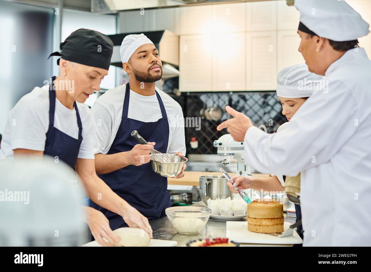 mature chief cook talking to african american young chef while his ...