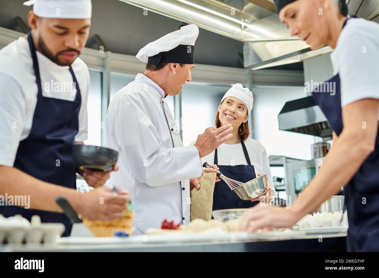 jolly young female chef in toque smiling at her mature chief cook next ...
