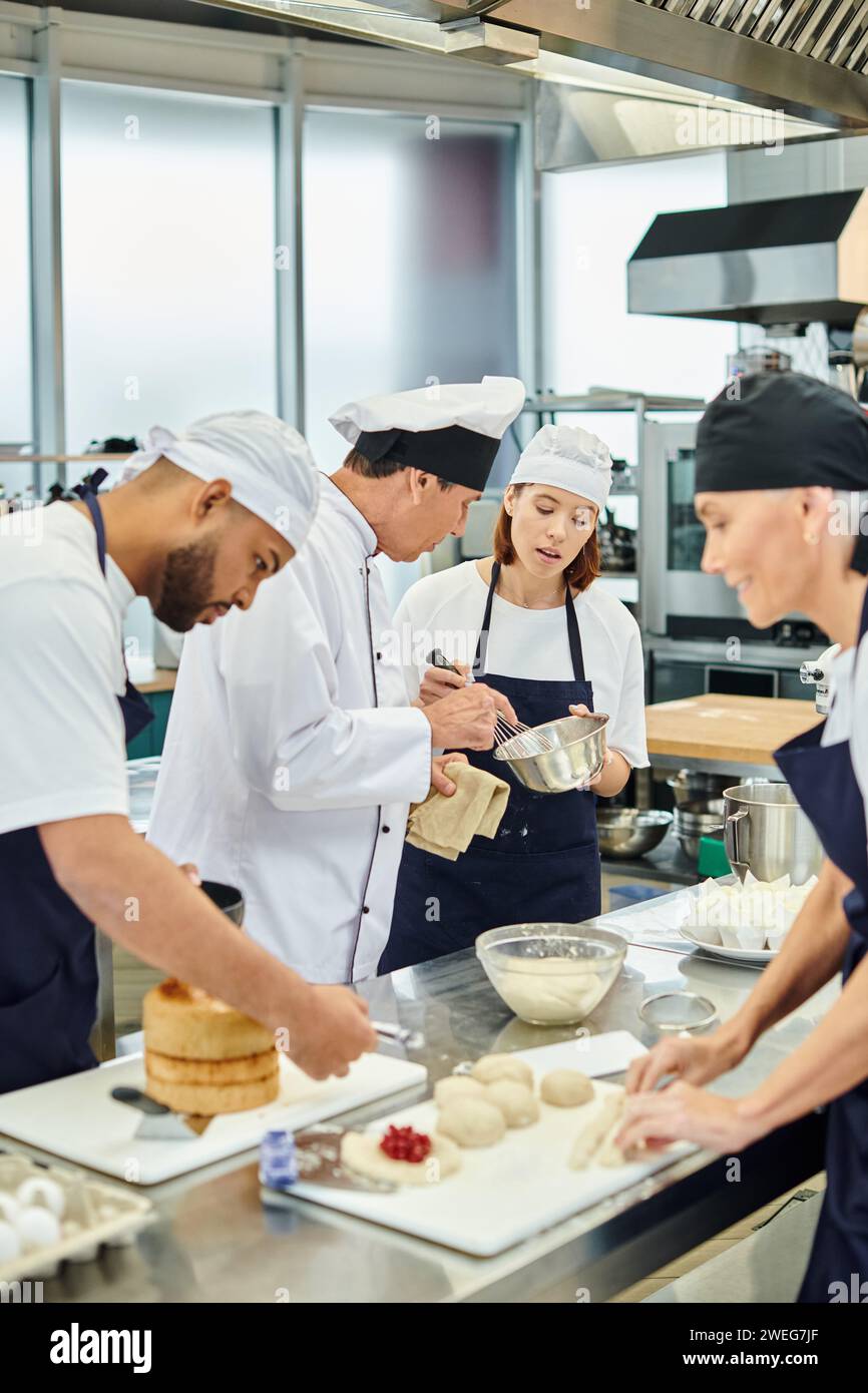 good looking mature chief cook working with his multicultural chefs on ...