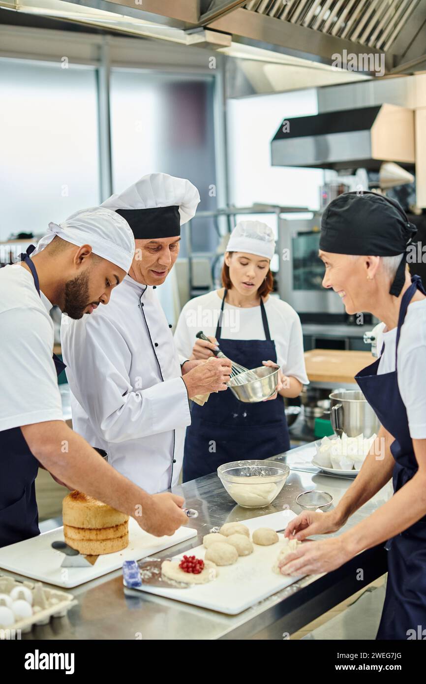 handsome mature chief cook in white hat working with his team of ...