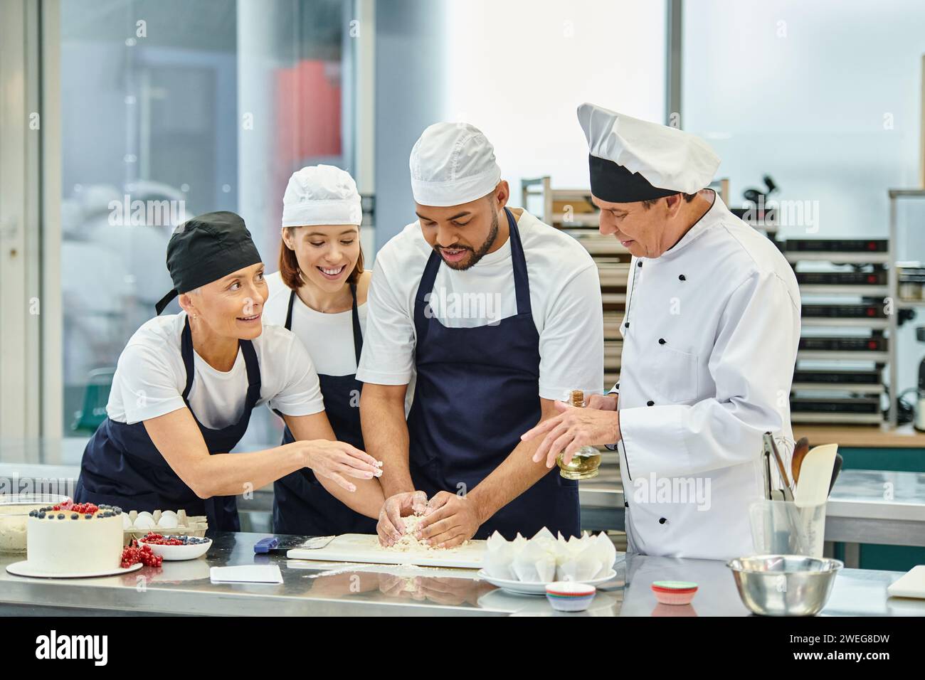 cheerful multicultural chefs in blue aprons working together with dough ...