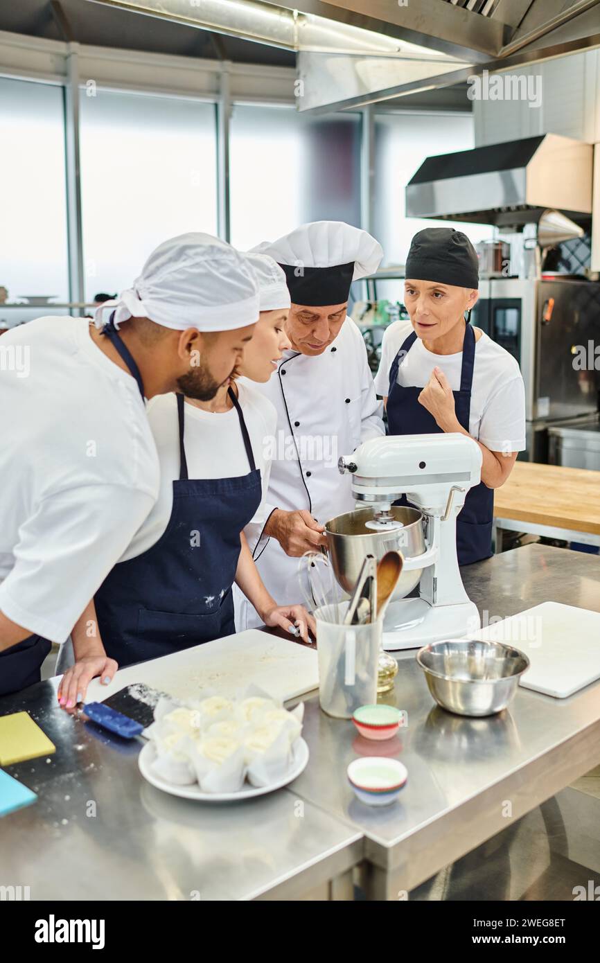 good looking multiracial chefs in aprons watching their chief cook ...