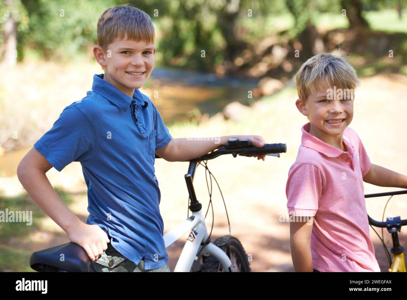 Nature, bicycles and portrait of boy children riding in outdoor field ...