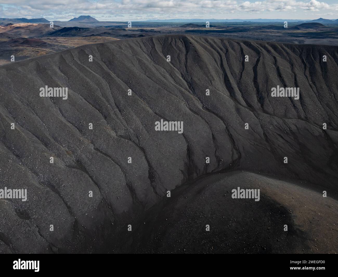 Black volcanic sand surface on the crater rim, close up aerial view ...