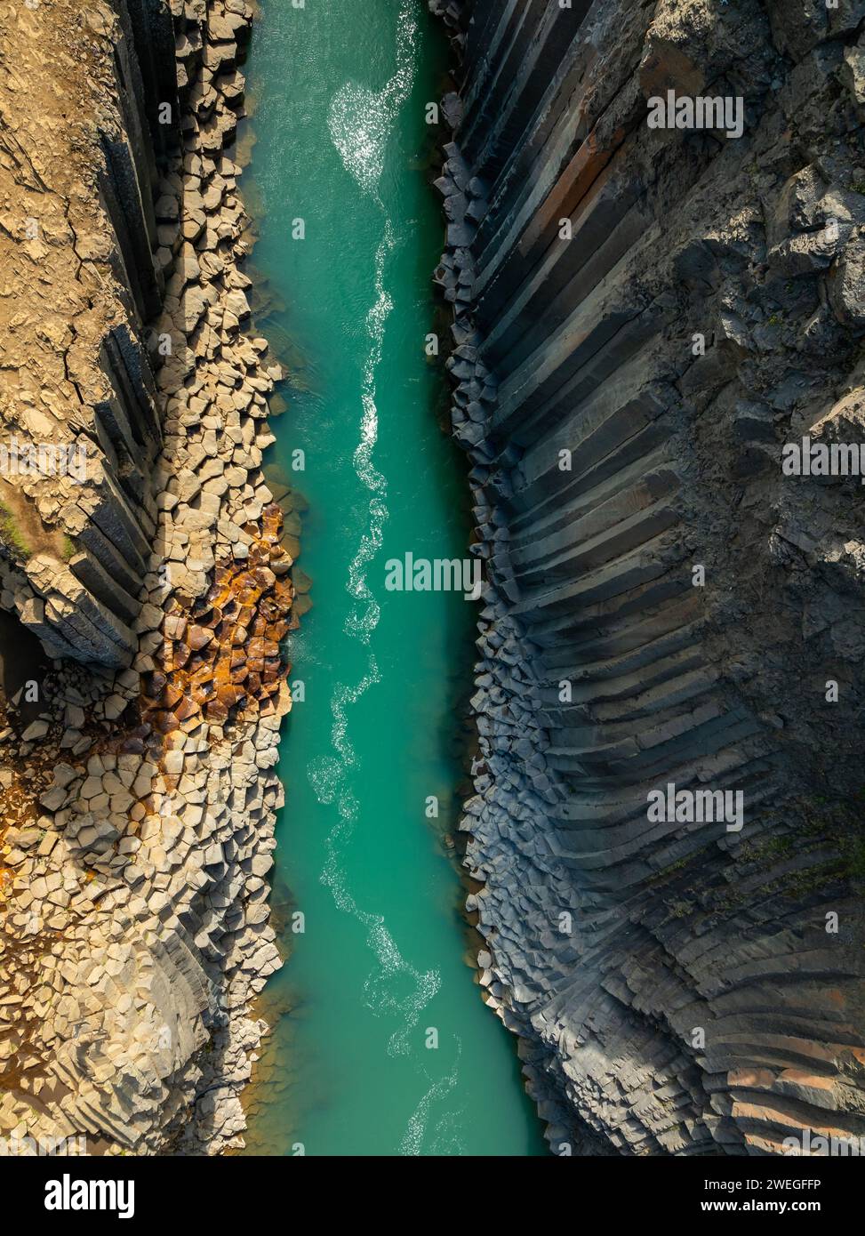 Canyon of magnificent basalt columns, high cliff with bright turquoise river, in North East ...