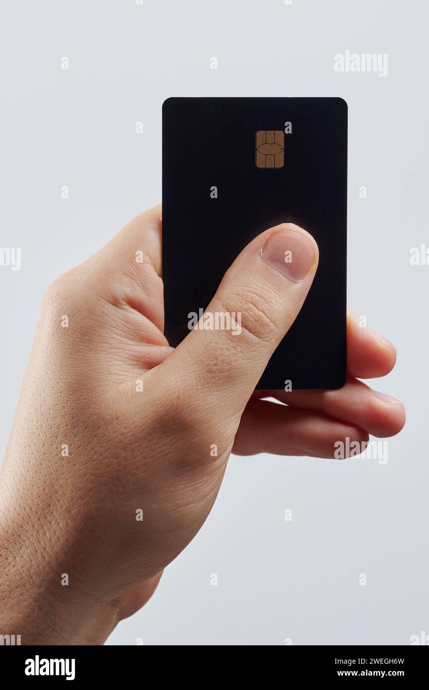 Hand hold black bank plastic card isolated on white studio background ...